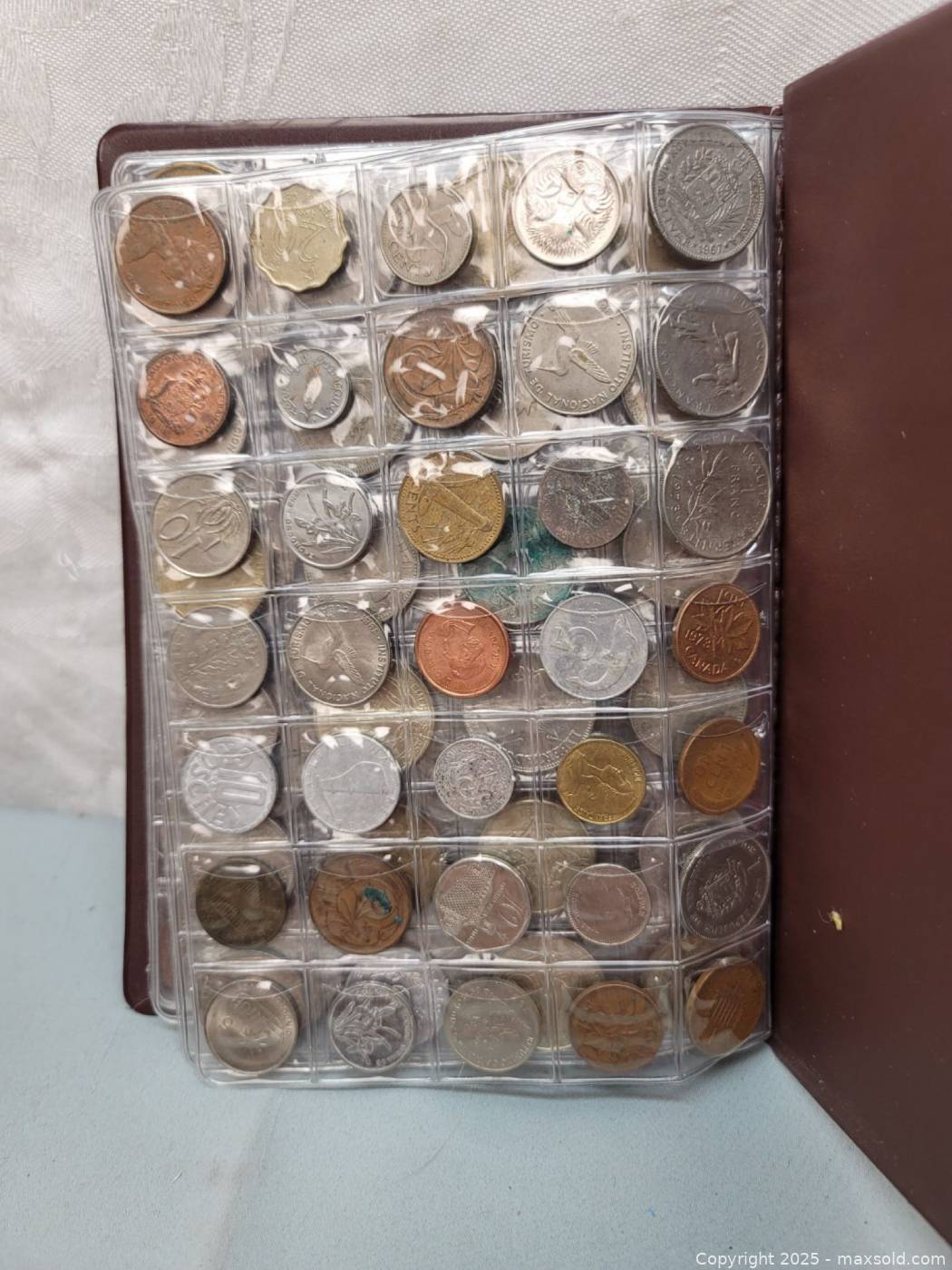 Uni-Safe Coins of the World album with ±120 assorted world coins | Maxsold