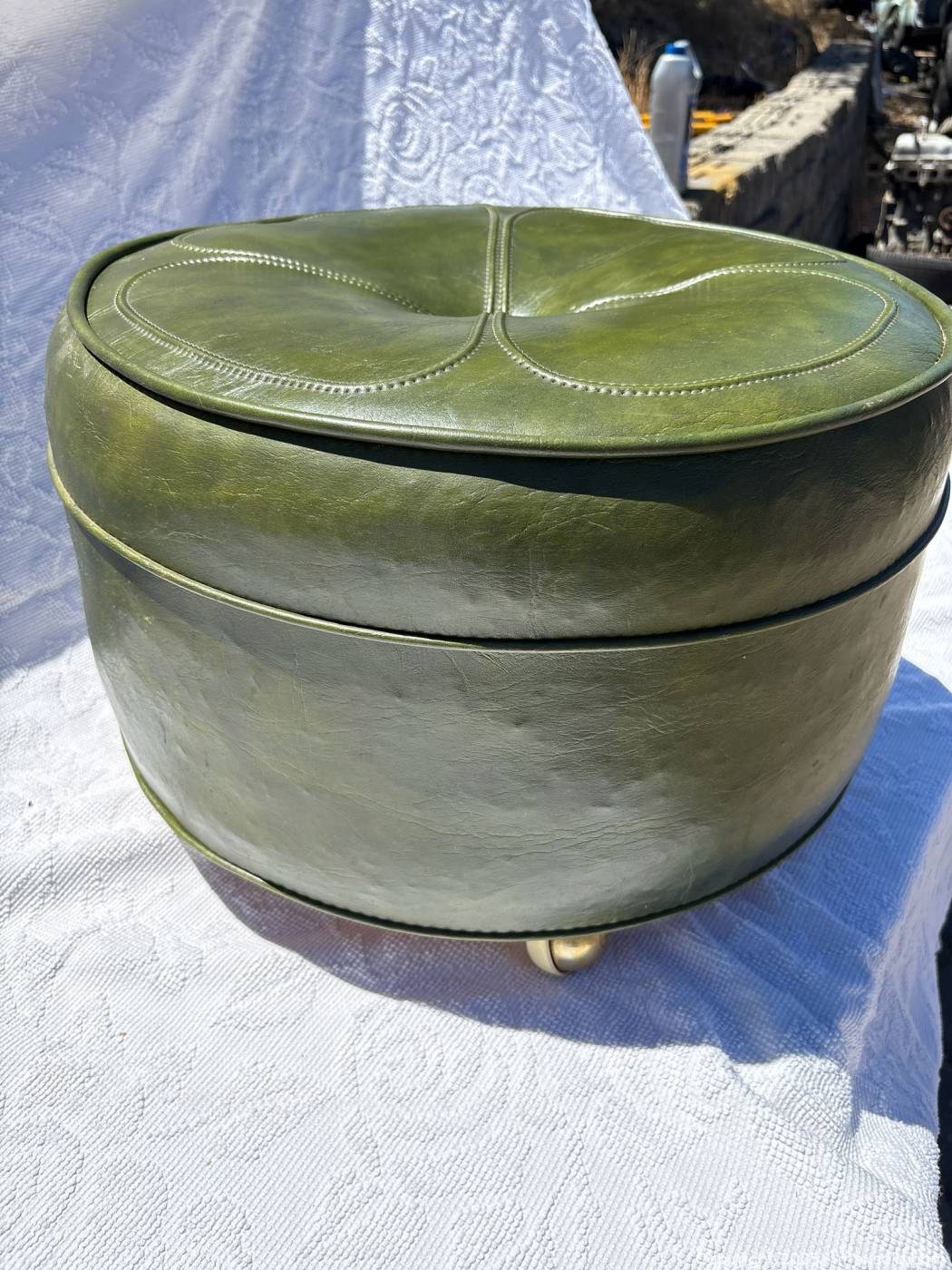 Round green vinyl ottoman on casters | Maxsold