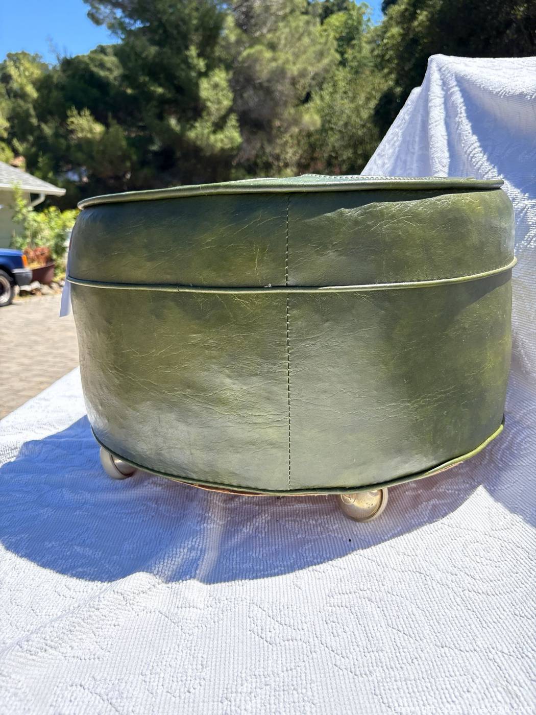 Round green vinyl ottoman on casters | Maxsold