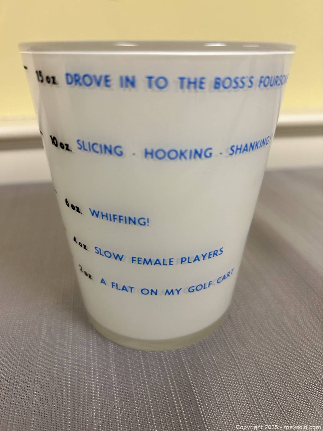 Humorous golfer measuring drinking glass | Maxsold