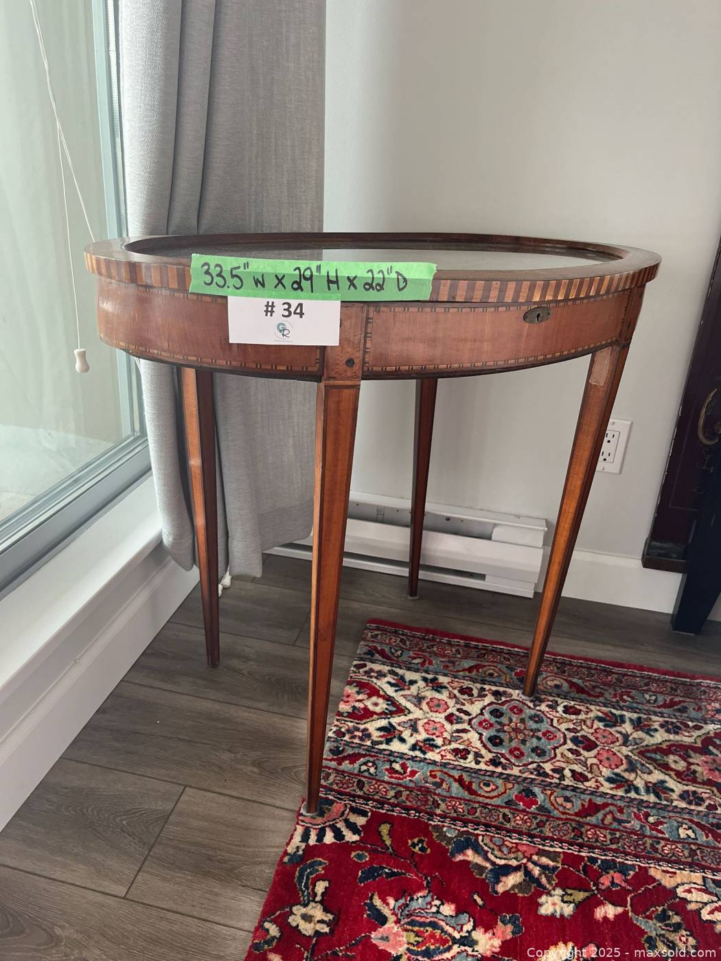 Oval glass-top inlaid display table | Maxsold