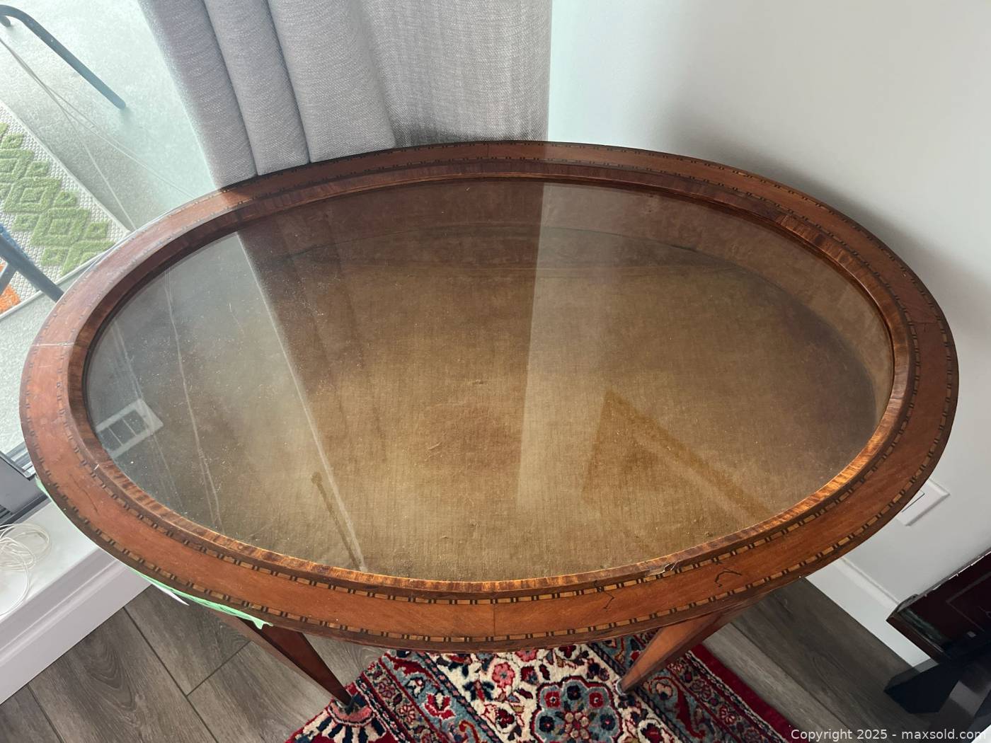 Oval glass-top inlaid display table | Maxsold