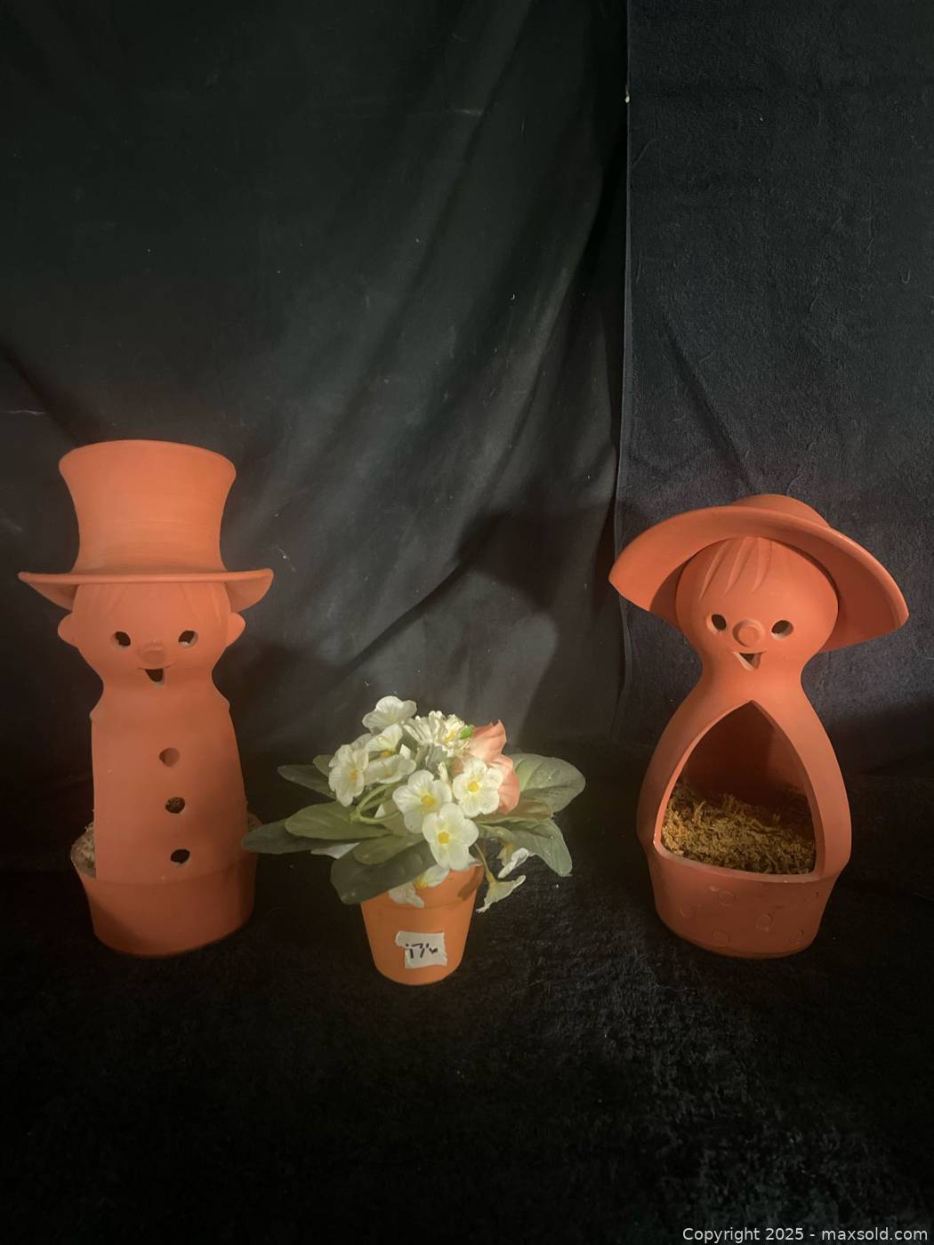 Terracotta figurine planters and faux flower arrangement | Maxsold