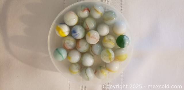 Vintage glass marbles in four round plastic containers | Maxsold