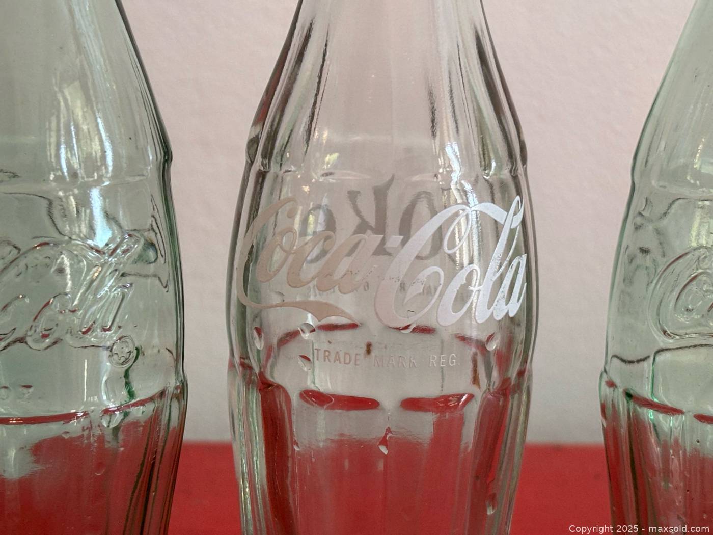 Three Coca-Cola contour glass soda bottles | Maxsold