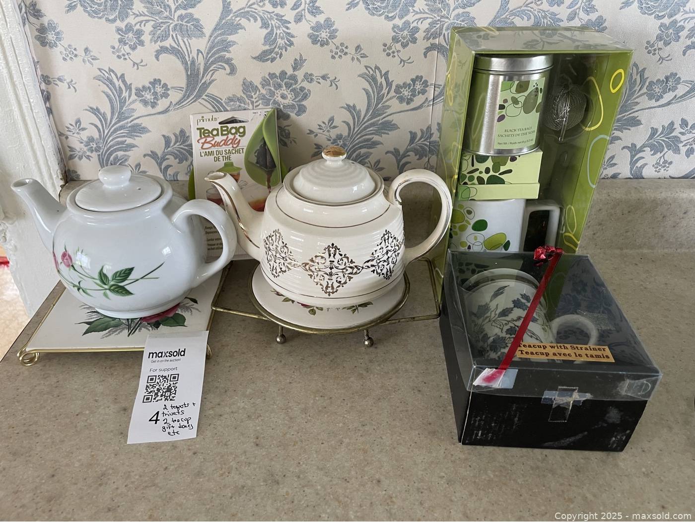 Two teapots, trivet tile, metal stand, boxed tea infuser mug set, boxed tea accessory set, tea ...