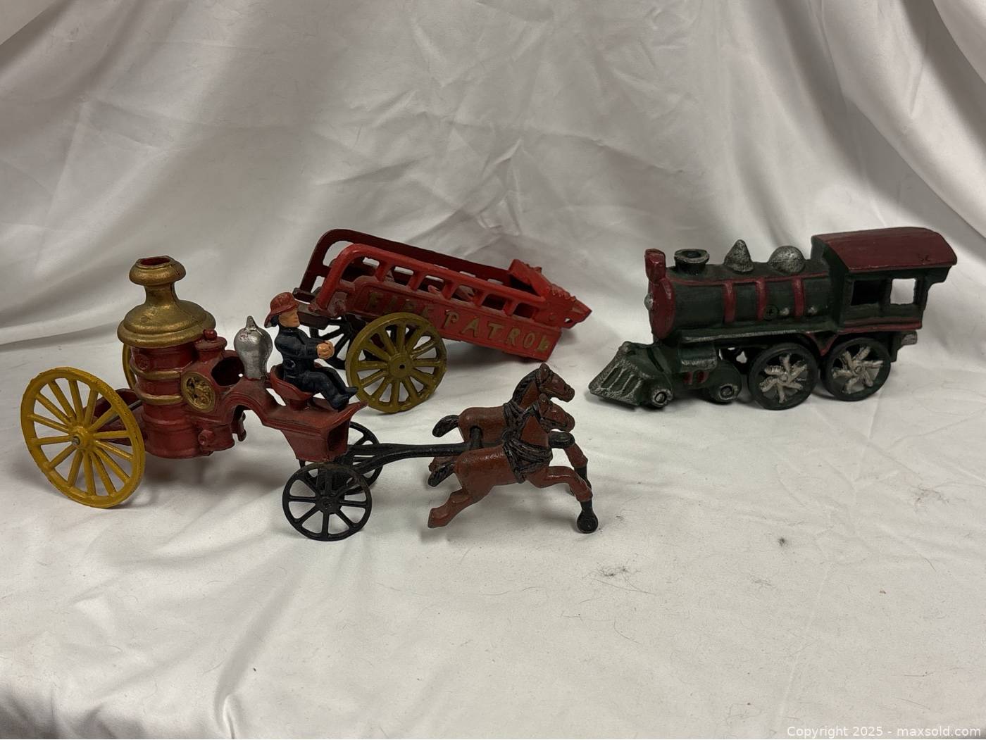 Cast iron toy lot, horse-drawn fire engine, ladder wagon, locomotive ...