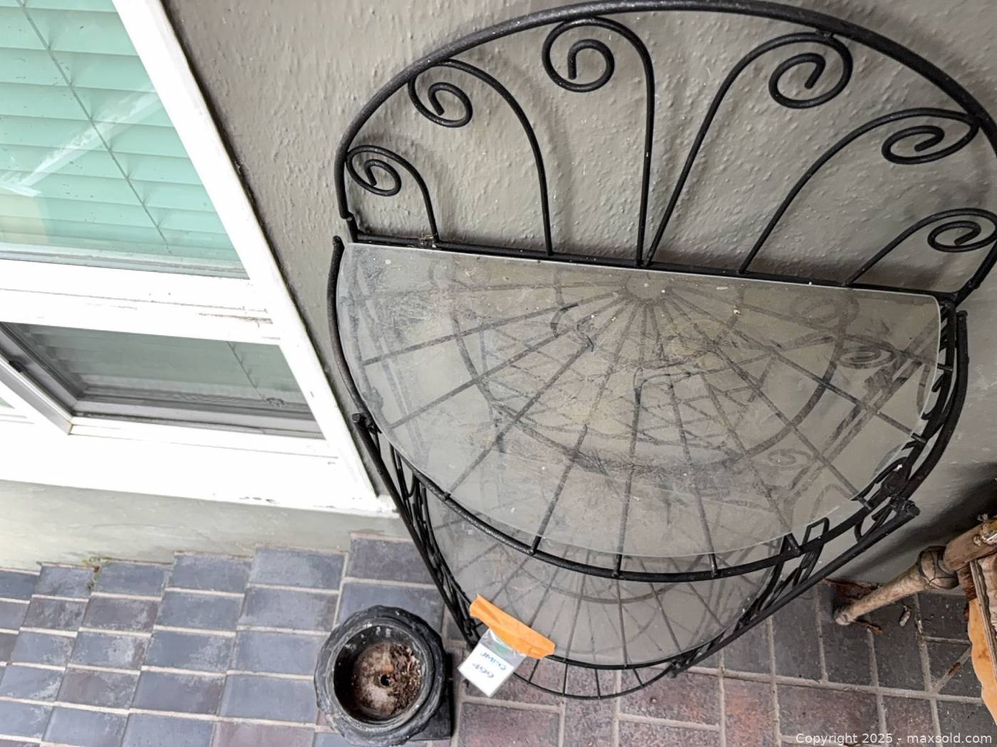 Black wrought-iron half-moon shelf with glass tiers and urn planter ...
