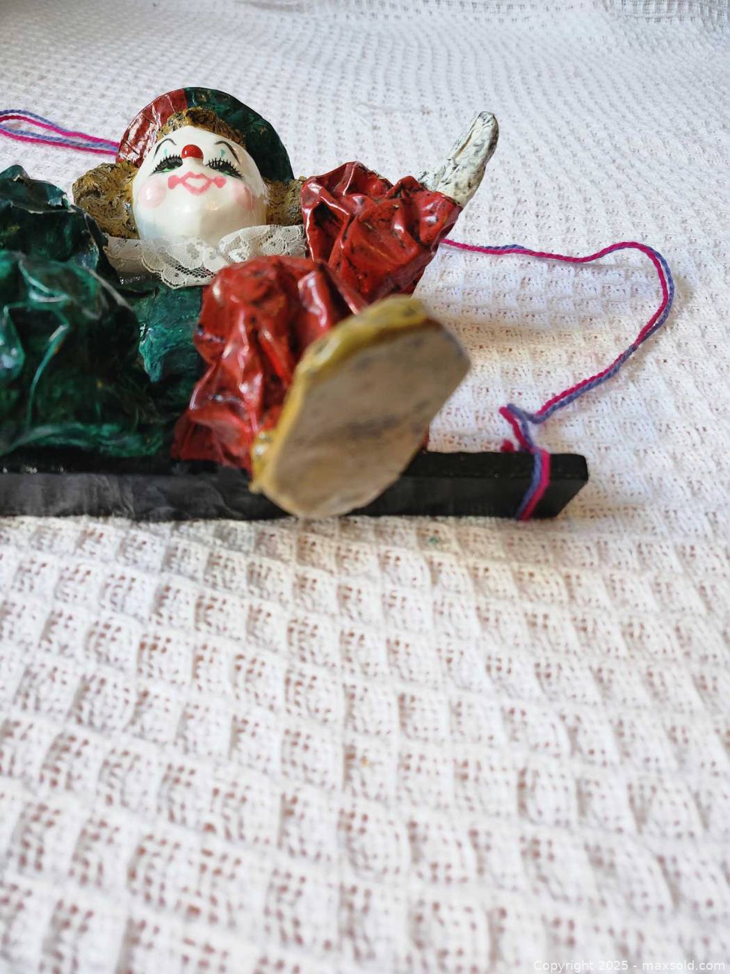 Vintage paper-mâché clown on wood trapeze | Maxsold