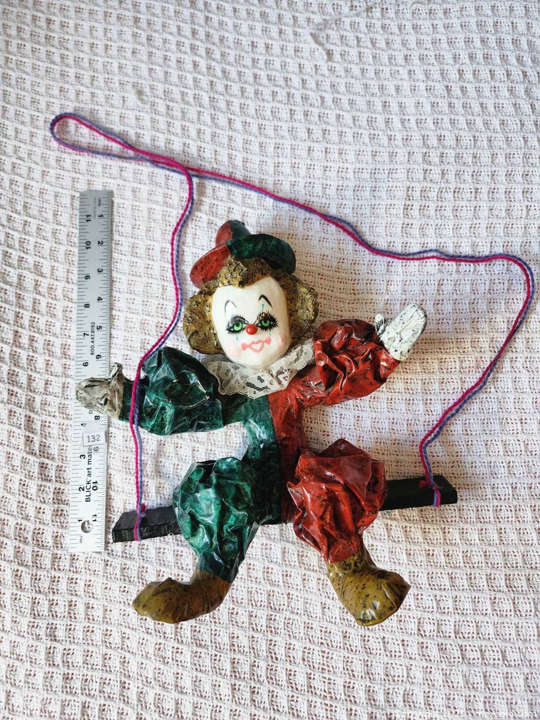 Vintage paper-mâché clown on wood trapeze | Maxsold