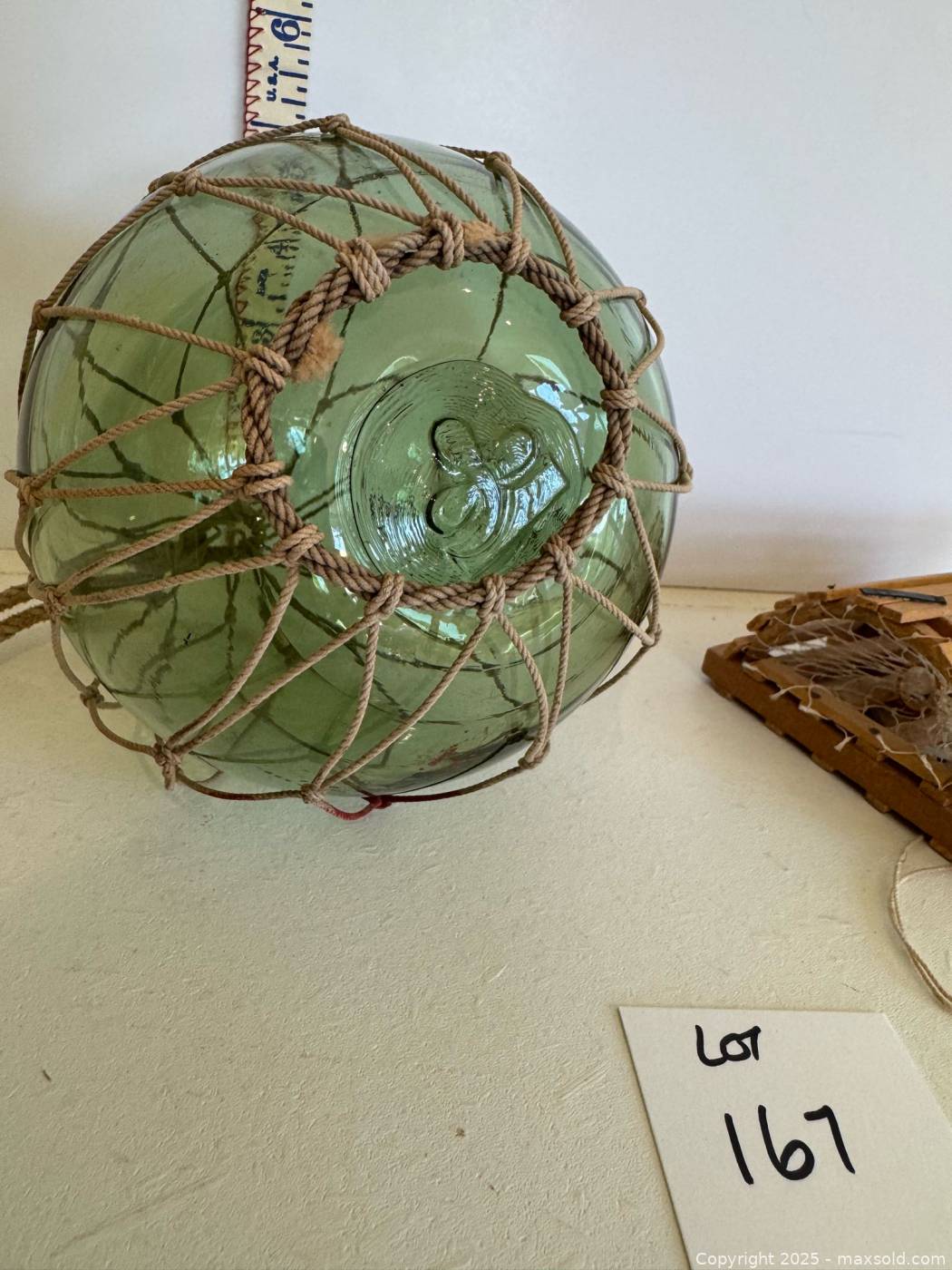 Green glass fishing float with rope netting and miniature wooden ...