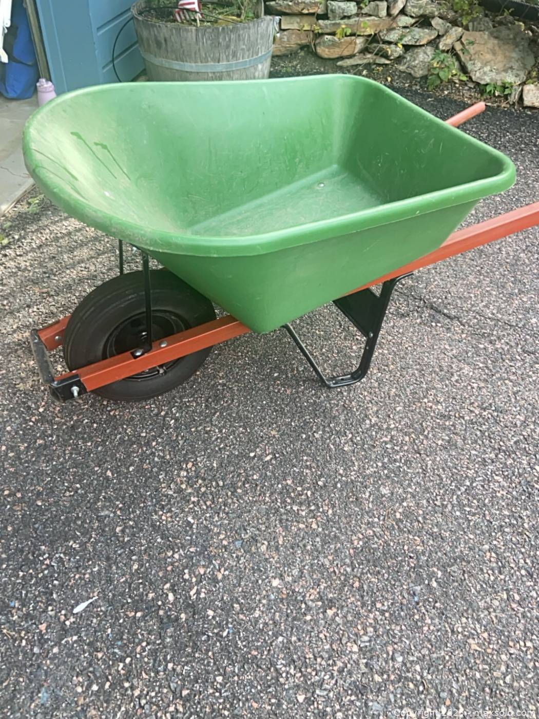 Green plastic wheelbarrow with wood handles | Maxsold