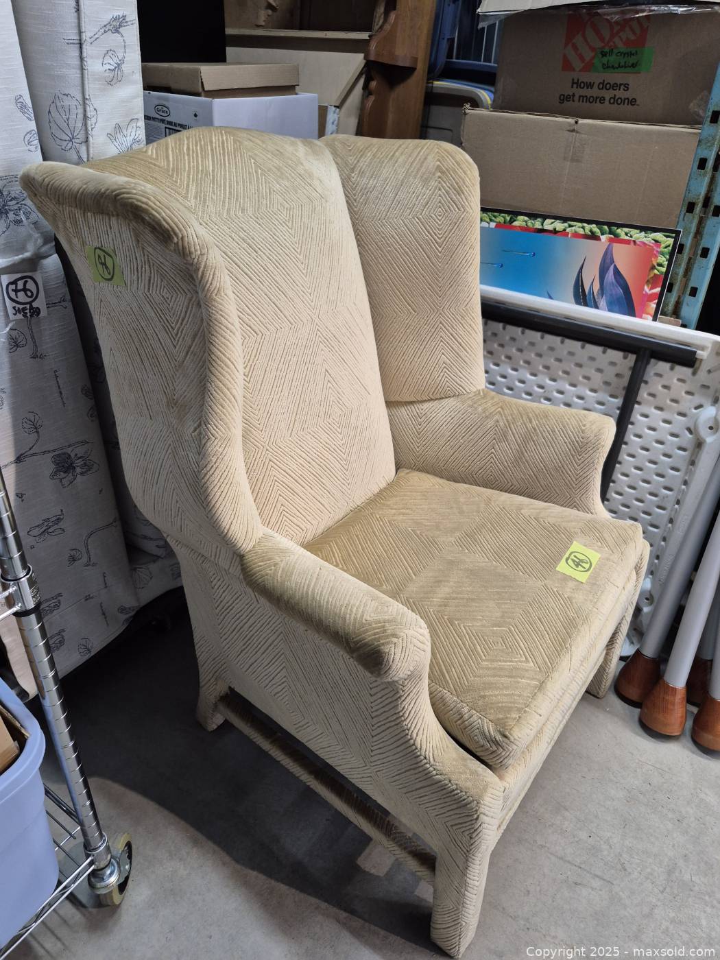 Beige upholstered wingback armchair | Maxsold