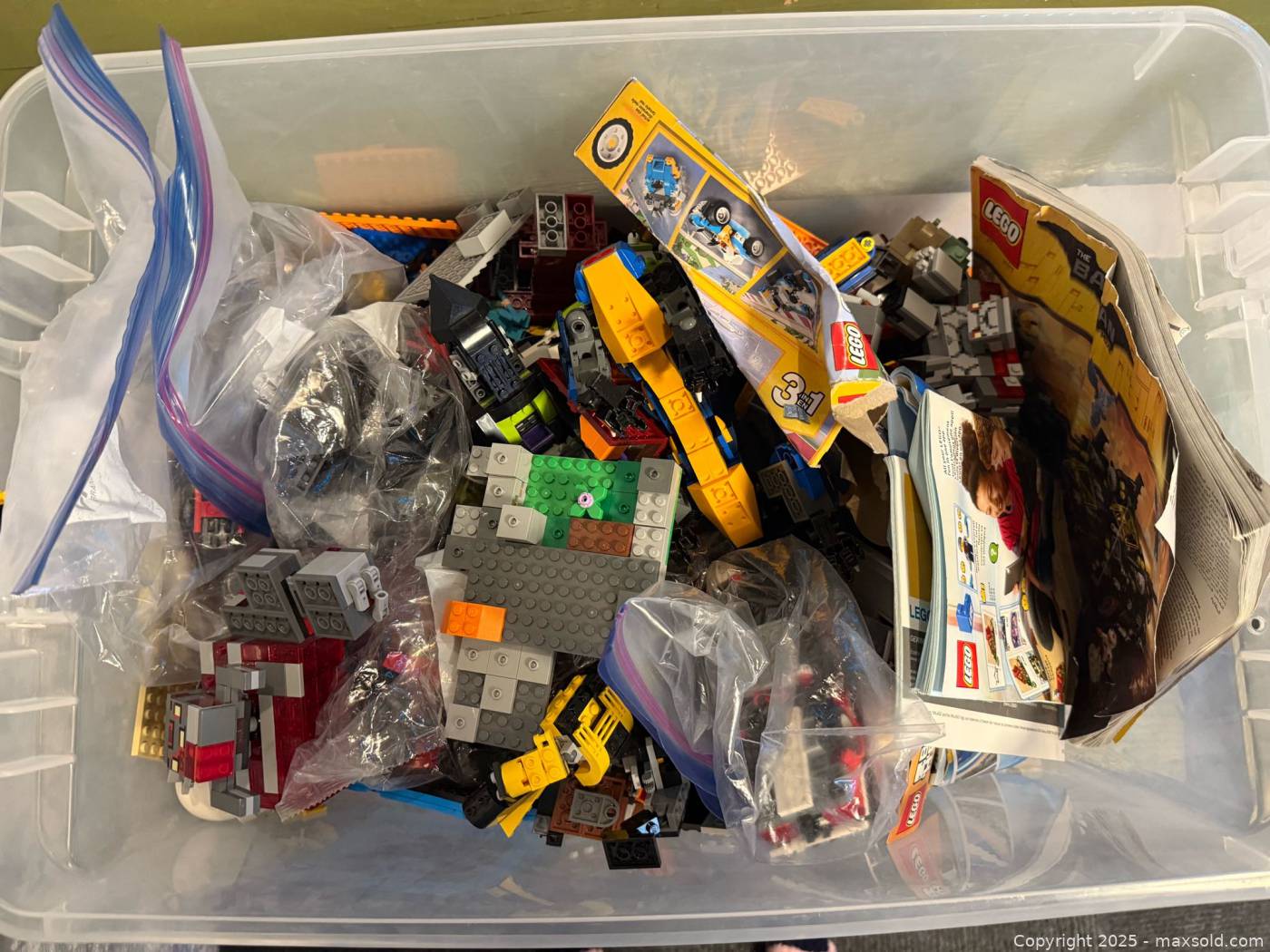 Clear tote of mixed LEGO bricks, manuals | Maxsold
