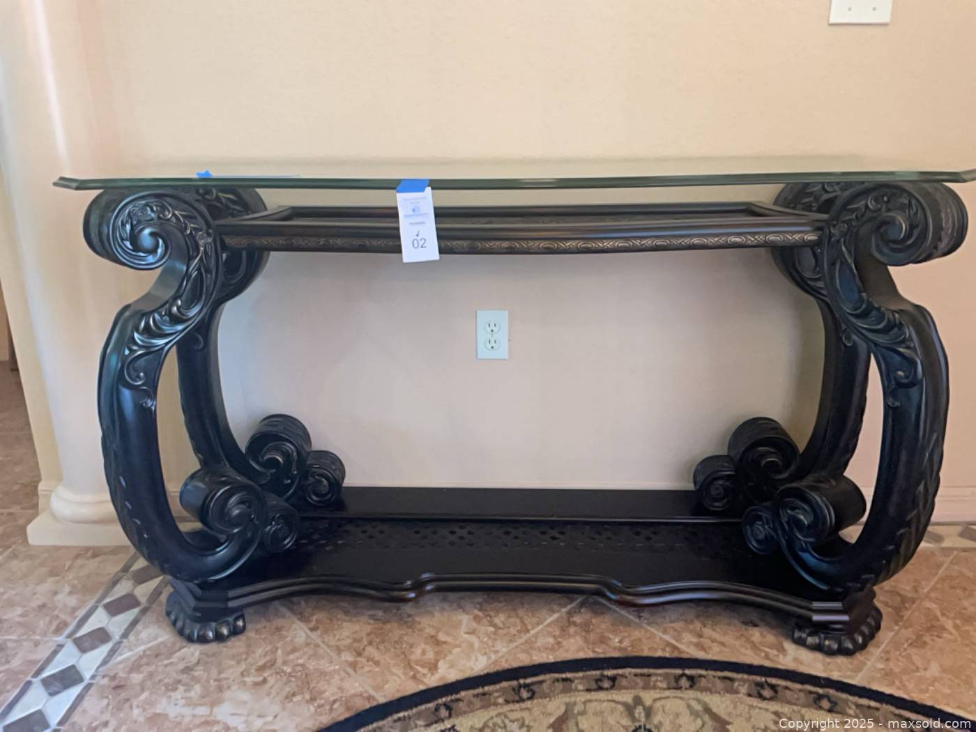 Ornate glass-top console table, carved wood base | Maxsold