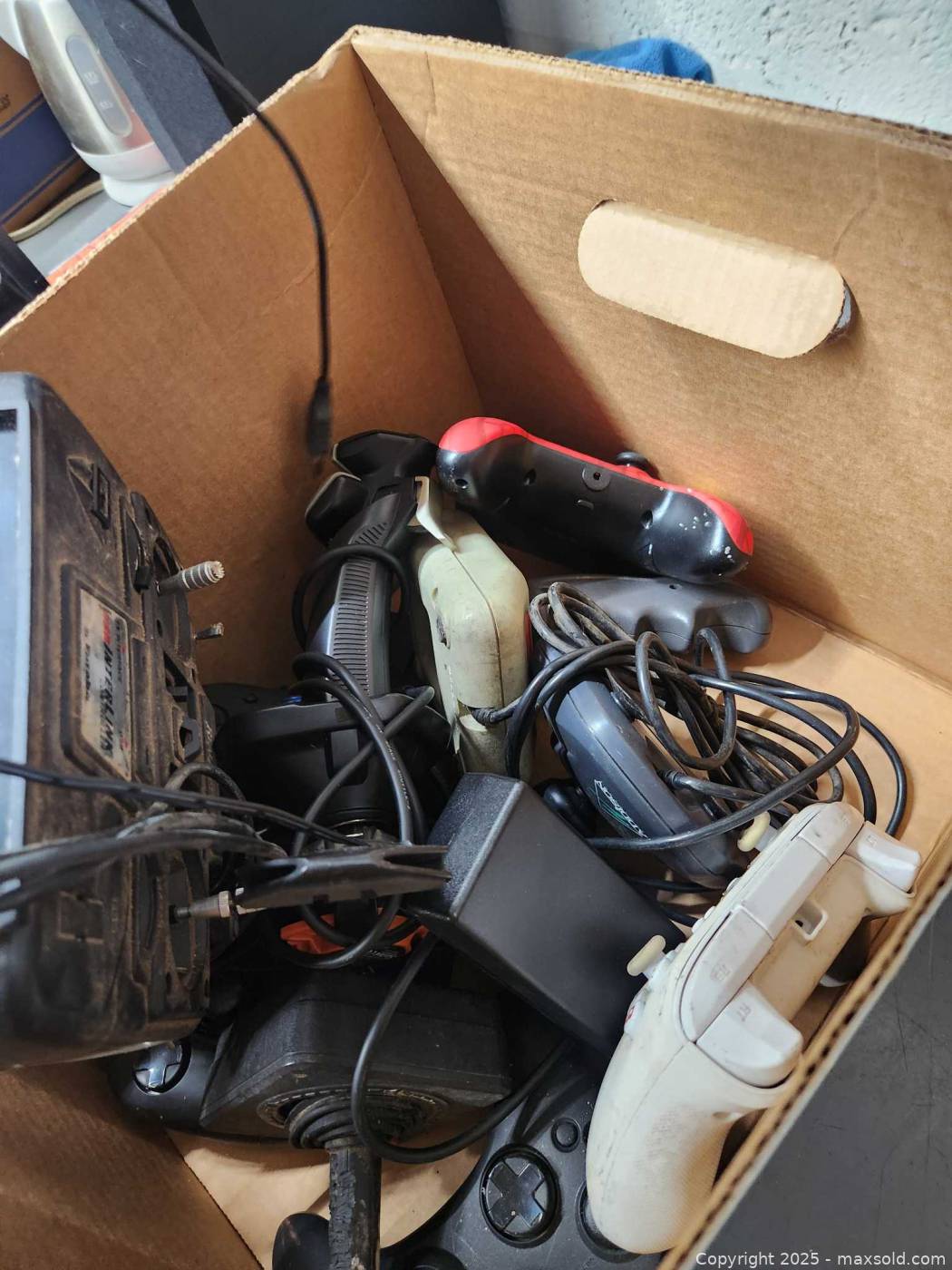Box of video game joysticks, wheel, controllers | Maxsold