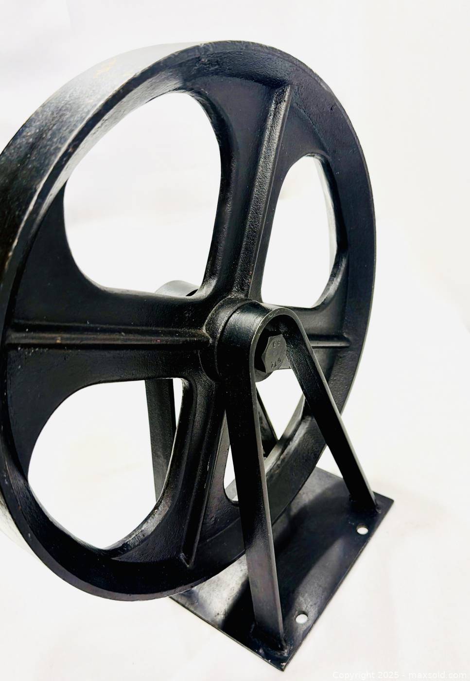Cast iron four-spoke wheel on base | Maxsold