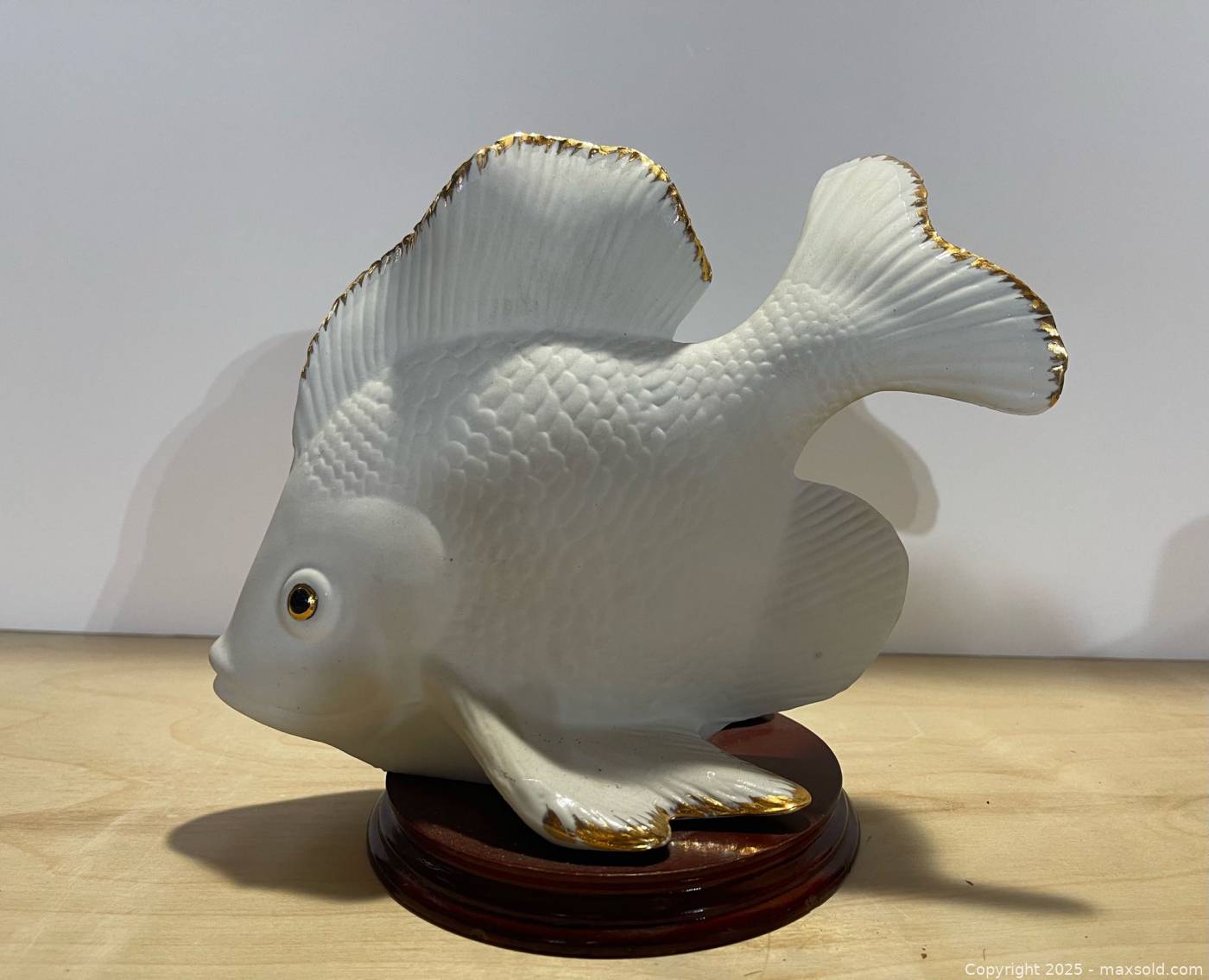 Off-white fish figurine on wood base | Maxsold