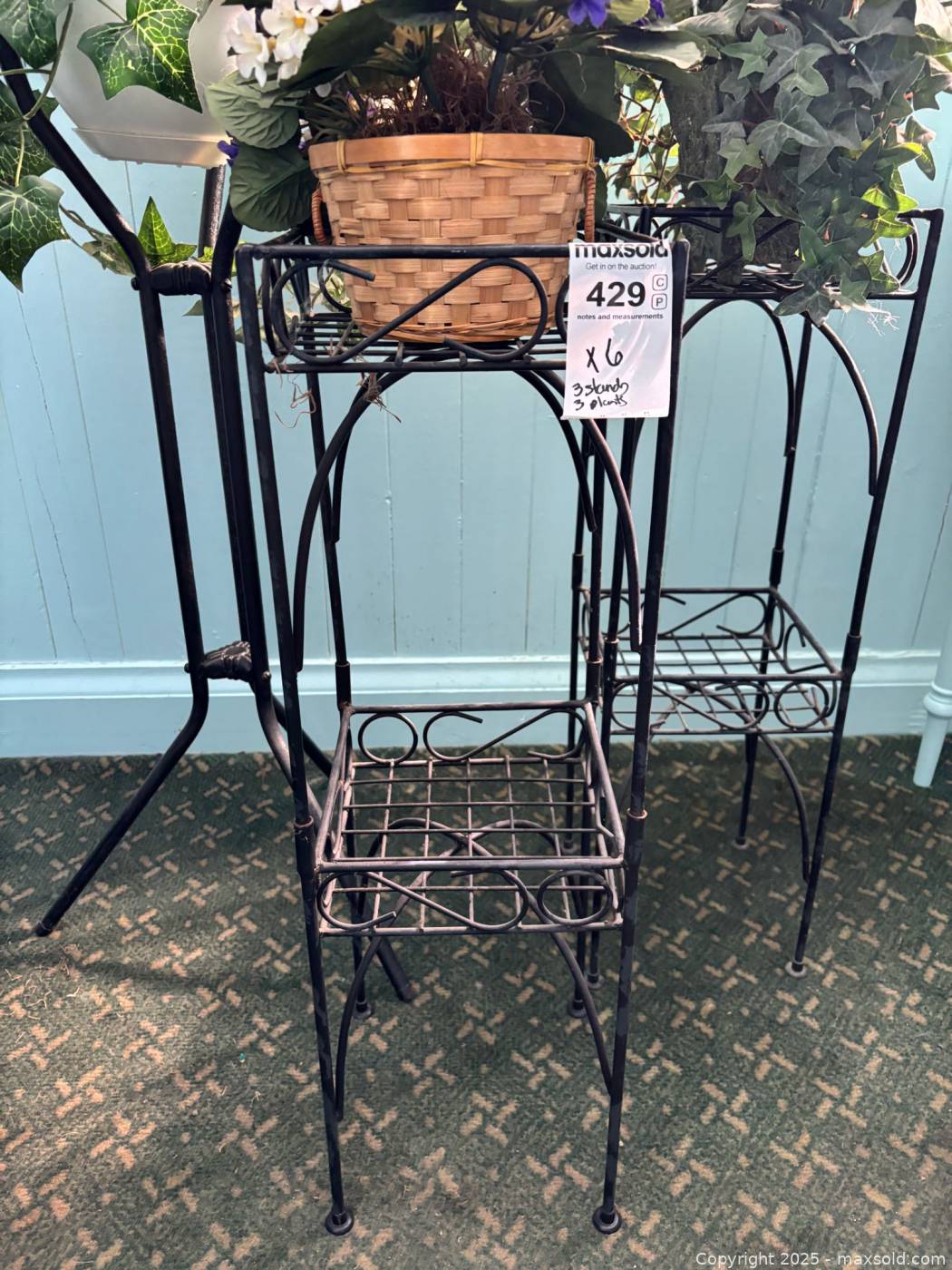 Three wrought iron plant stands with artificial plants | Maxsold