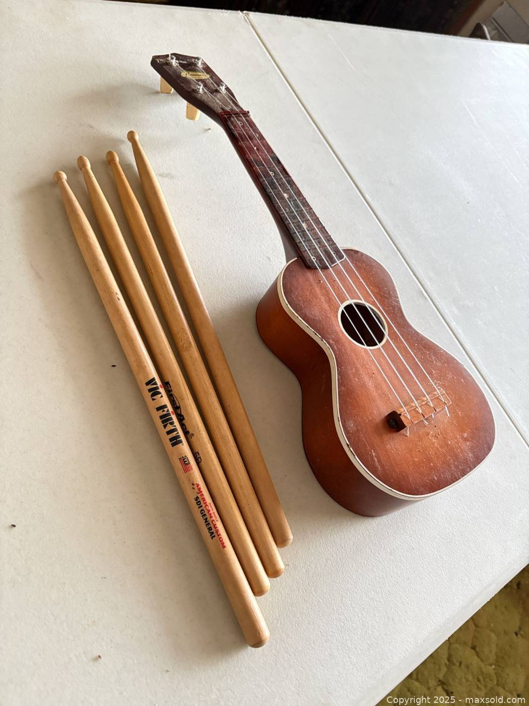 Soprano ukulele and four drumsticks | Maxsold