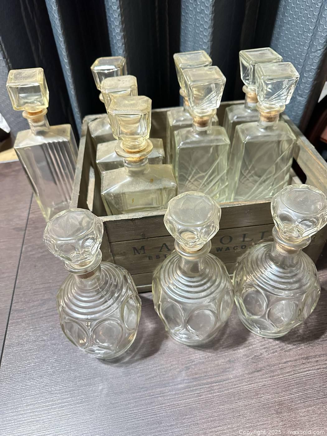 11 clear glass decanters with stoppers and wooden crate | Maxsold