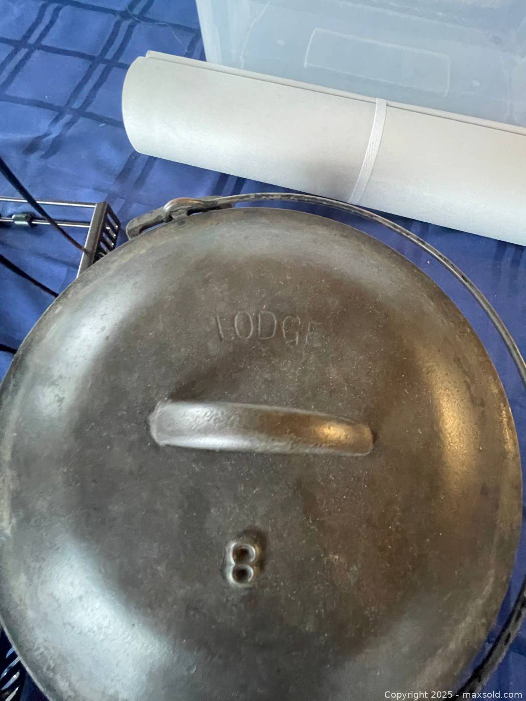 Lodge cast iron #8 pot with lid plus two black metal pan racks | Maxsold