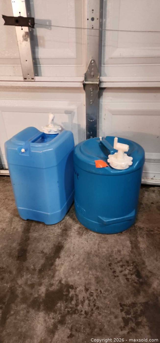 Two blue water transport containers with spigots | Maxsold