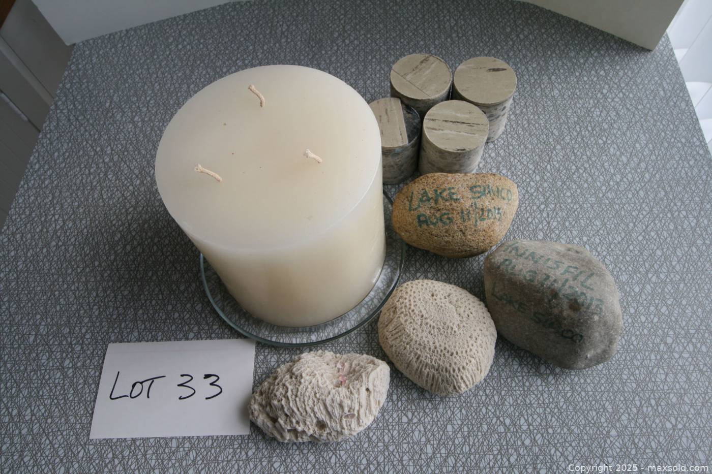Pillar candle, glass plate, stones, coral & five concrete cores | Maxsold