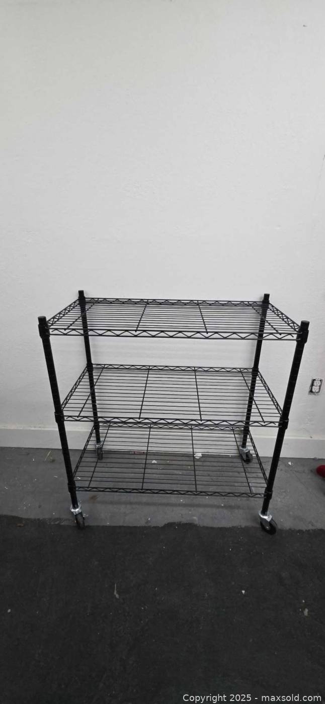Black rolling wire rack on locking casters | Maxsold