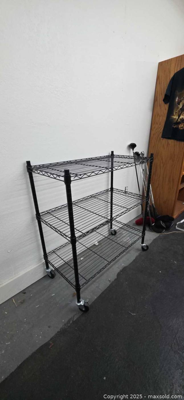 Black rolling wire rack on locking casters | Maxsold