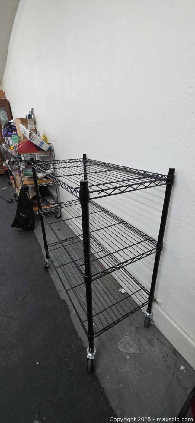 Black rolling wire rack on locking casters | Maxsold