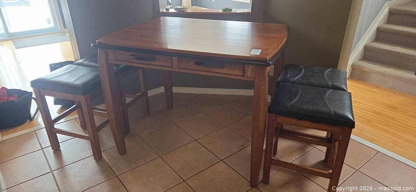 Counter-height wooden dining table with four upholstered stools | Maxsold