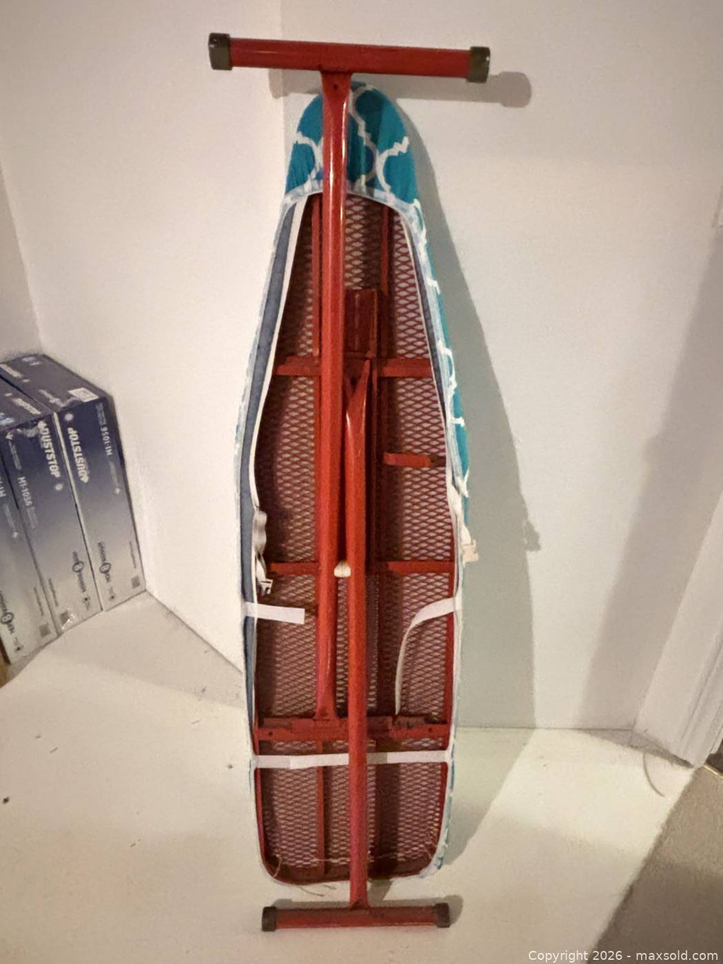 Metal ironing board with teal quatrefoil cover | Maxsold