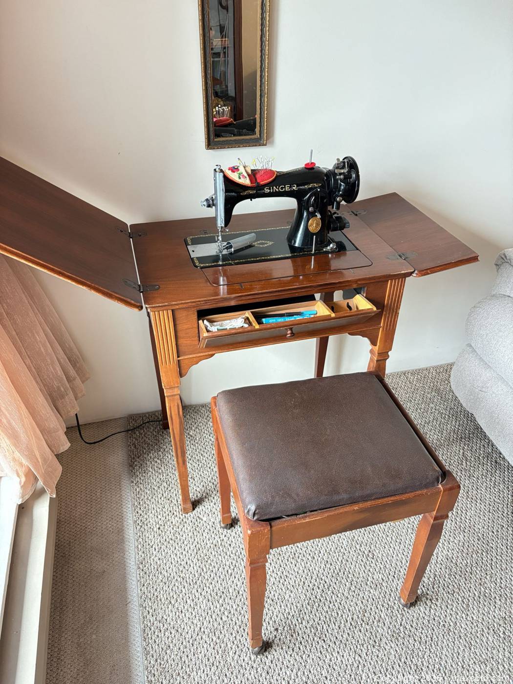 Singer electric sewing machine in flip-top cabinet with stool | Maxsold