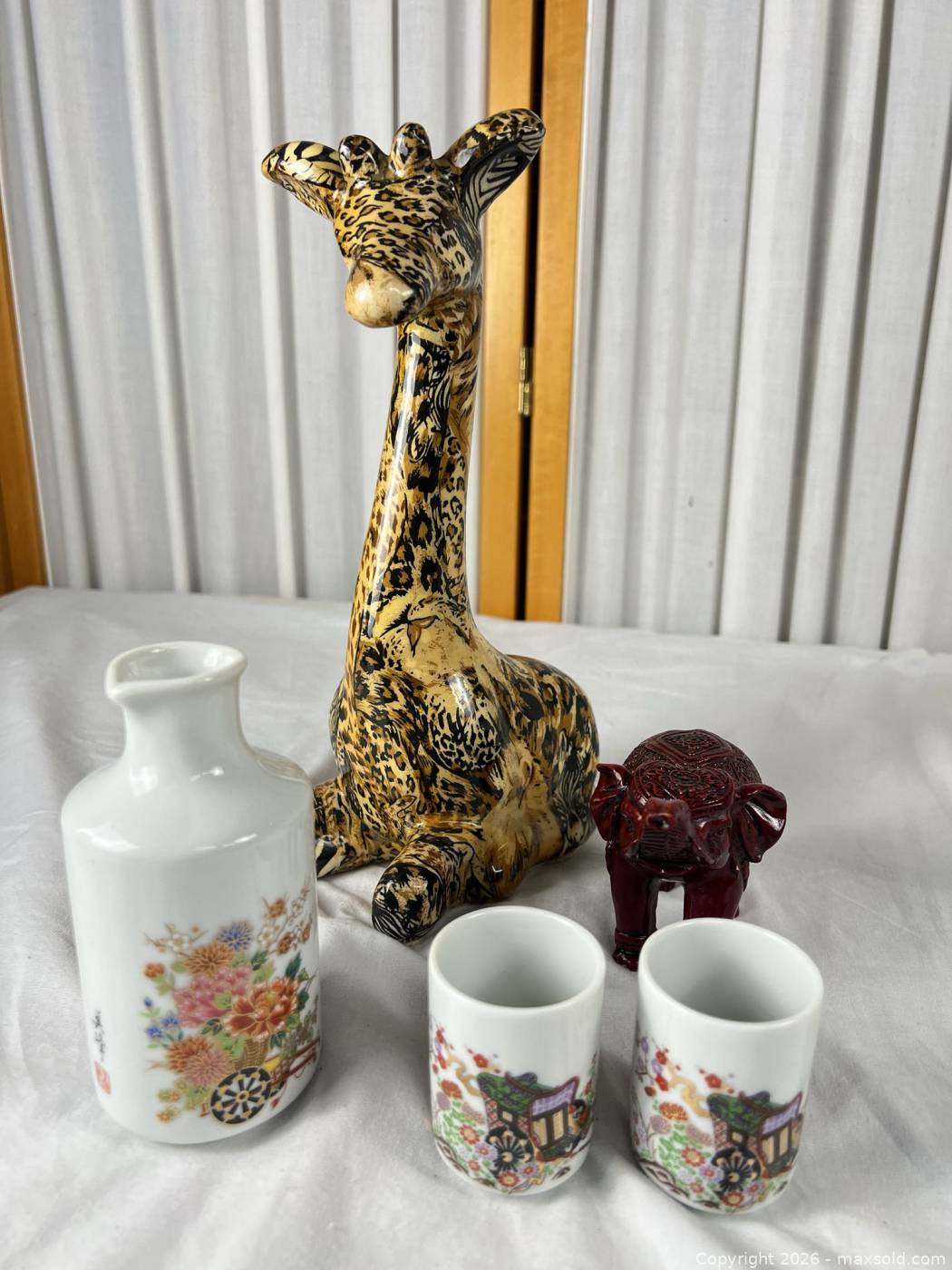 Porcelain sake bottle and cups with carved elephant and ceramic giraffe ...