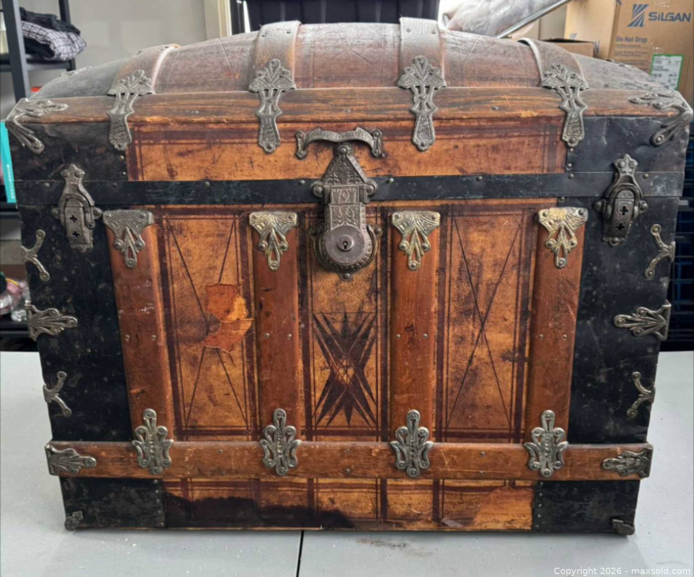 Antique domed wooden trunk with ornate metal hardware | Maxsold