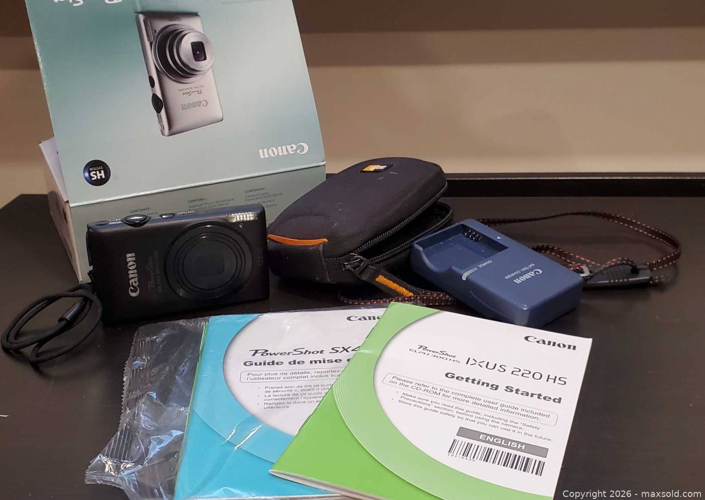 Canon PowerShot IXUS 220 HS digital camera with charger and case | Maxsold