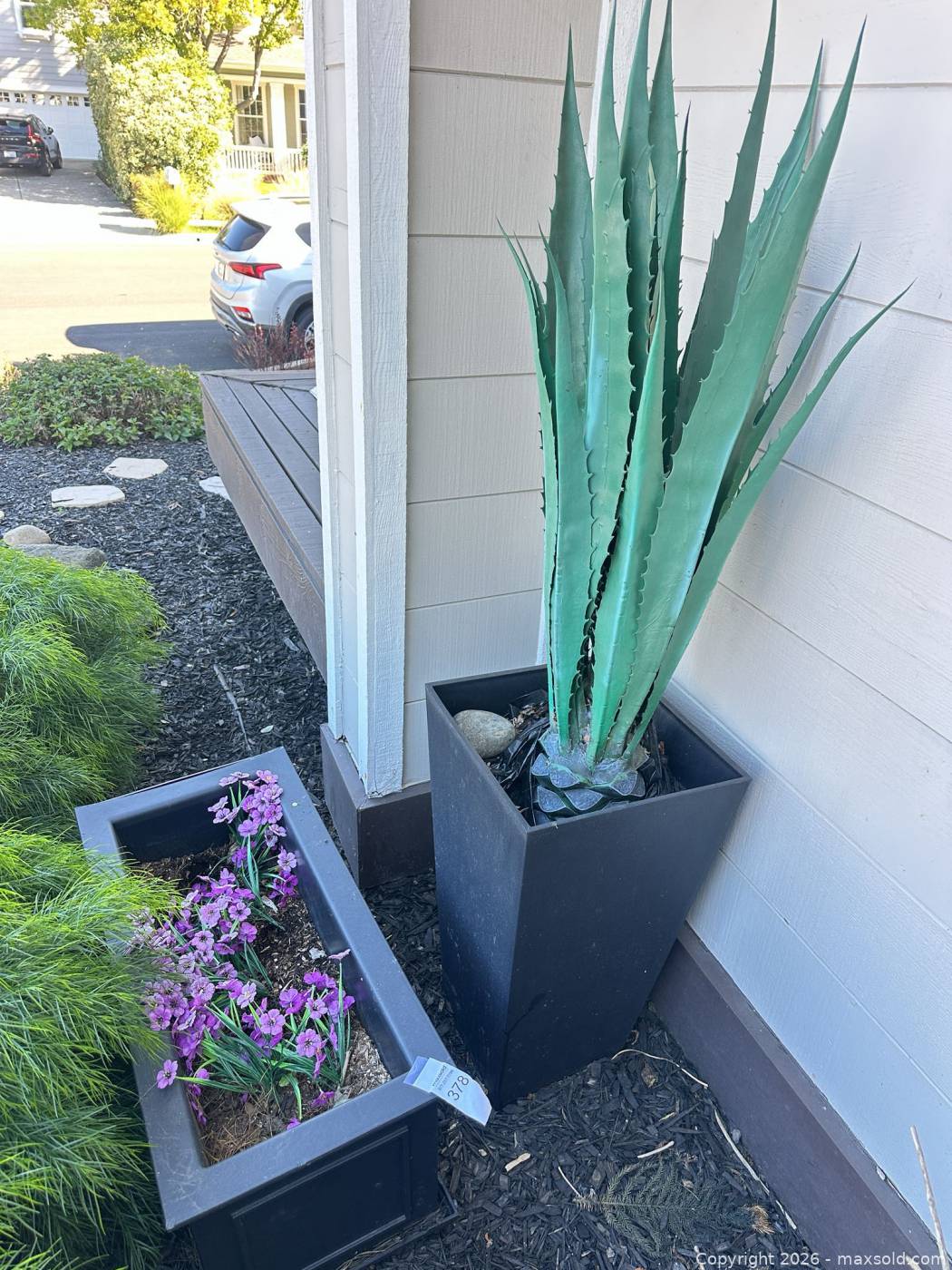 Pair of black outdoor planters with faux plants | Maxsold