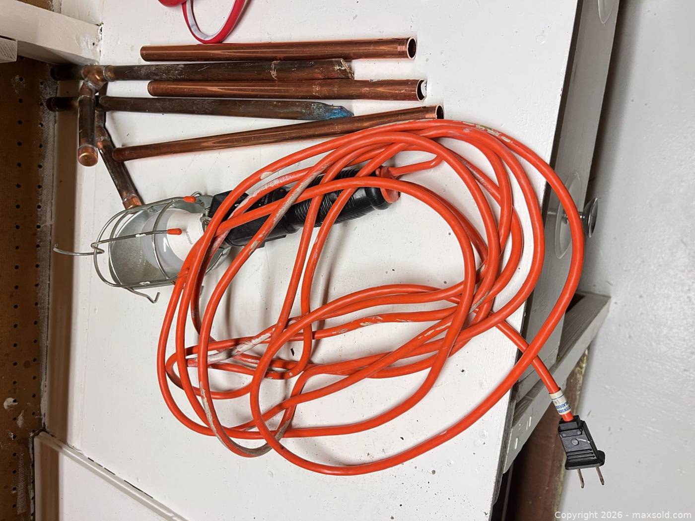 Extension cords, trouble light, copper pipe sections | Maxsold