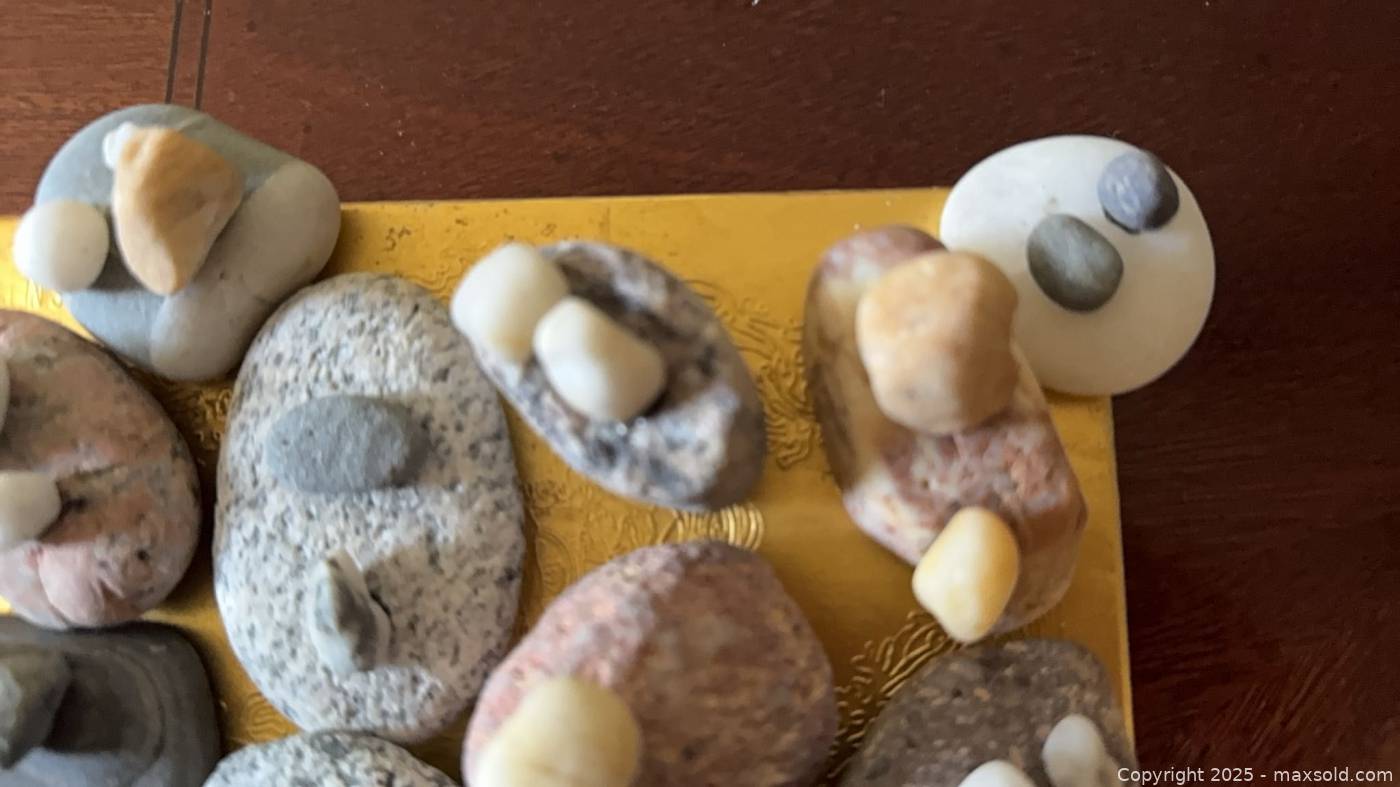 Pebble face rock art on gold base | Maxsold